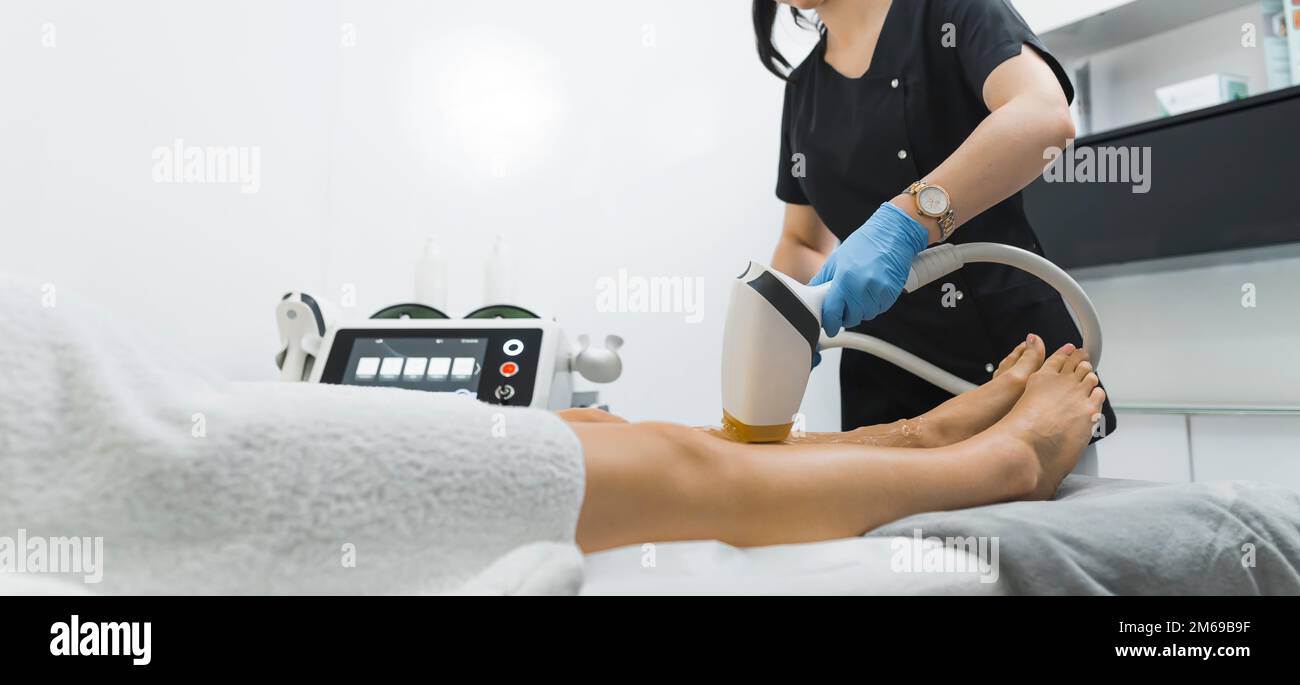 Hip level side shot of female legs during a laser hair removal ...