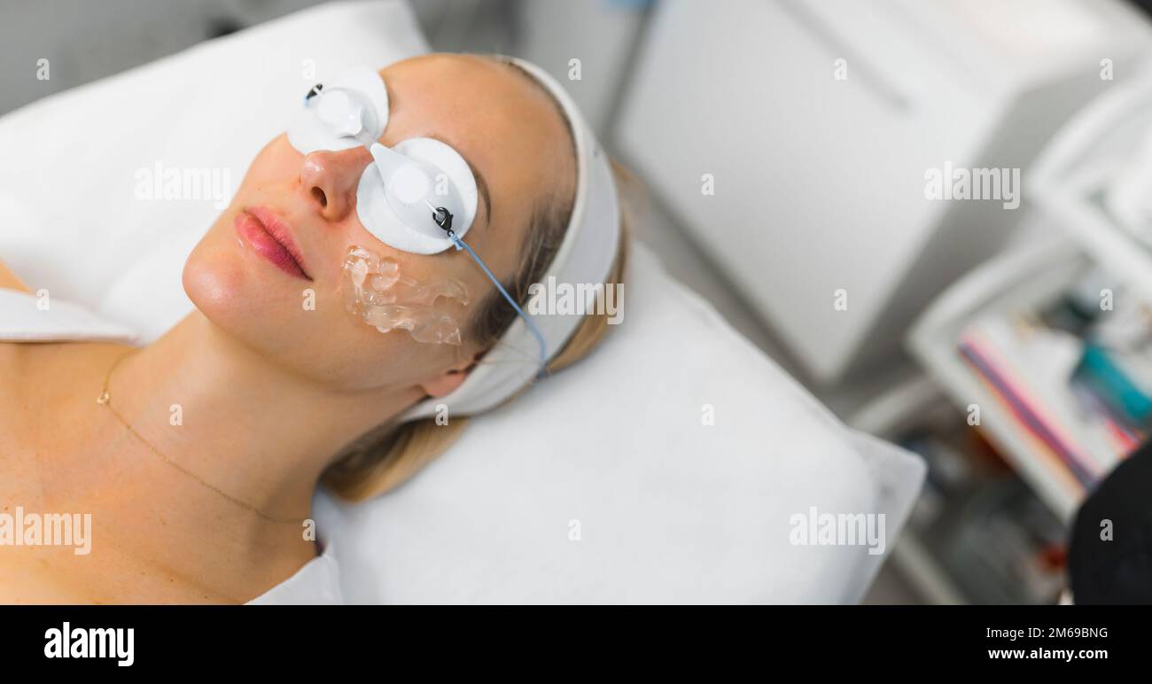 Close-up of a female face prepared for a thermolifting facial procedure ...