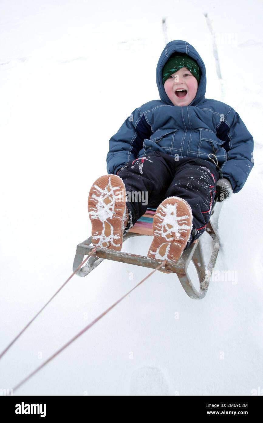 Winter riding of the boy on sled 2 Stock Photo - Alamy