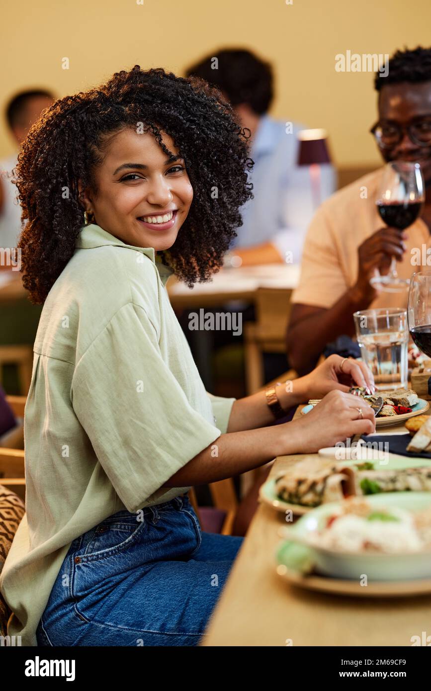 A happy Hispanic girl sits in a restaurant with her boyfriend and has ...