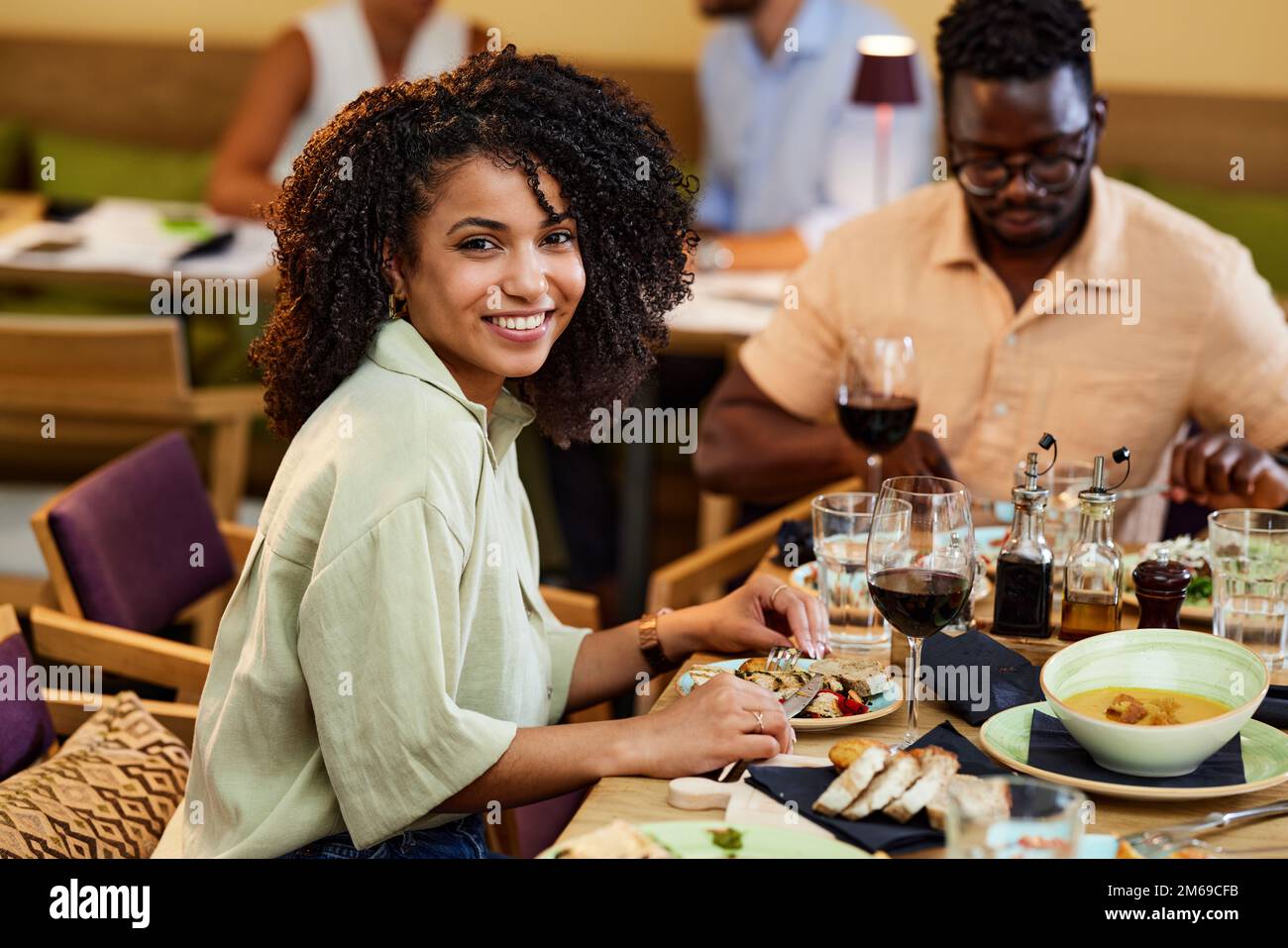 A Hispanic girl eats dinner in a restaurant with her friend Stock Photo ...