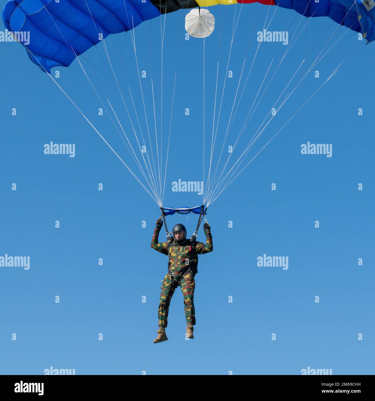 A Belgian Paratrooper slows down his parachute for landing as ...