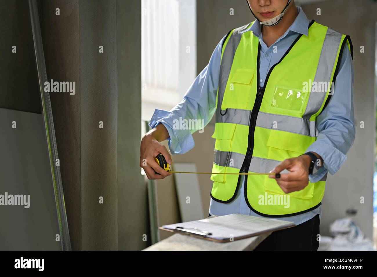 Engineer or inspector working with blueprints with measure tape in his ...