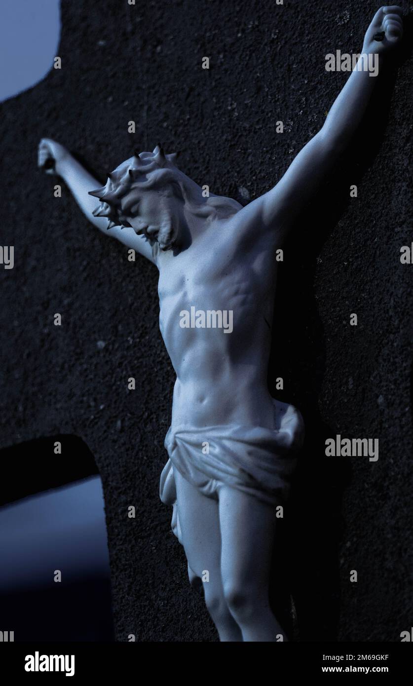 A vertical shot of a statue of Jesus Christ crucified on a black cross Stock Photo - Alamy
