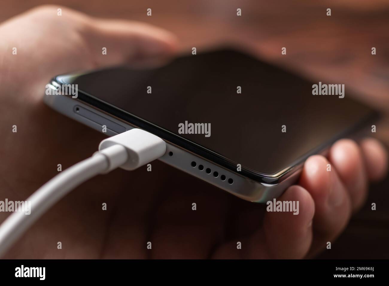 Man hands plugging a charger in a smart phone Stock Photo - Alamy