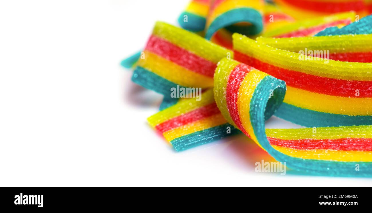 rainbow sour jelly candies strips in sugar sprinkle on white background ...