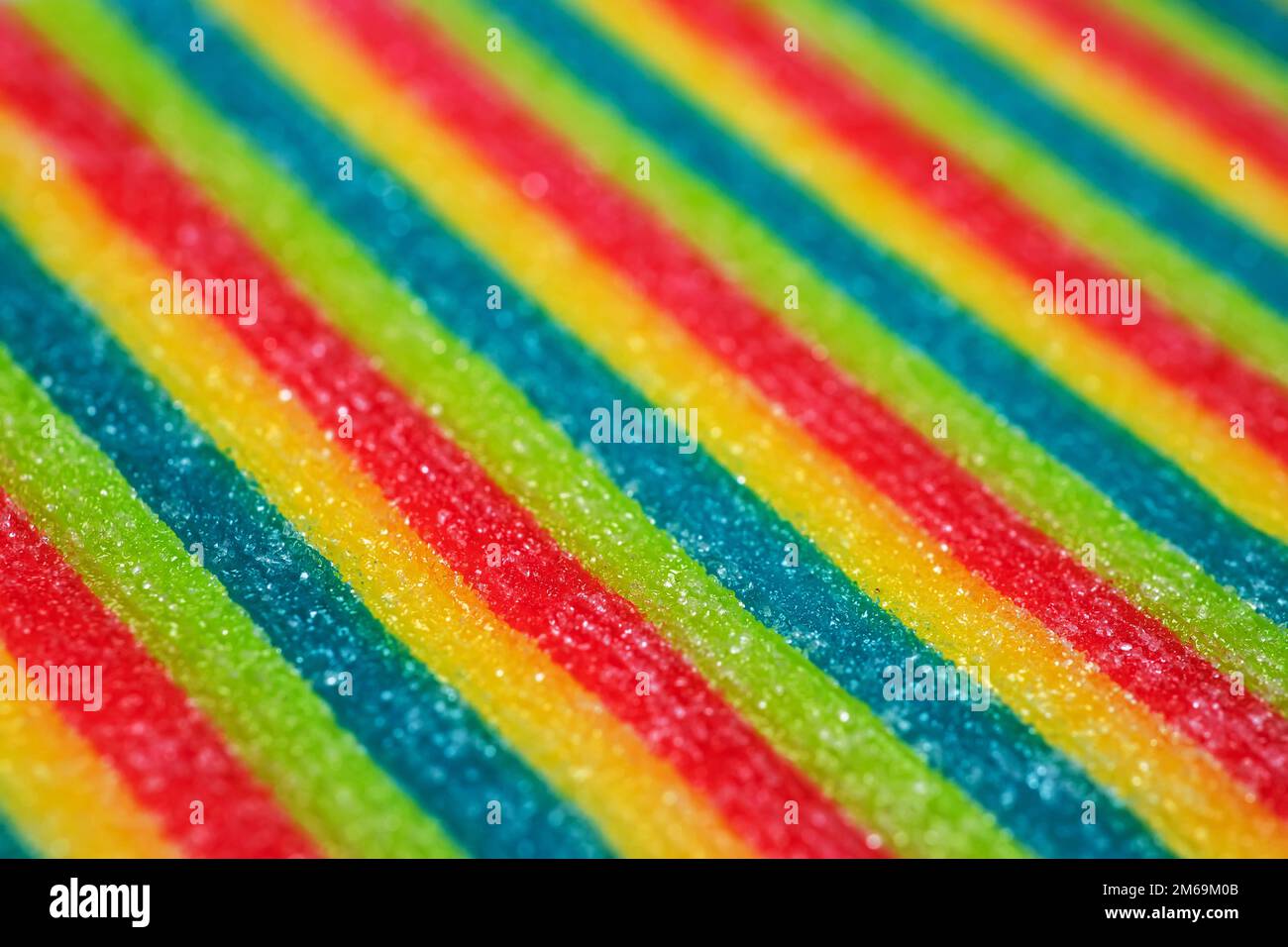 Background of rainbow sour jelly candies strips in sugar sprinkle. Top ...