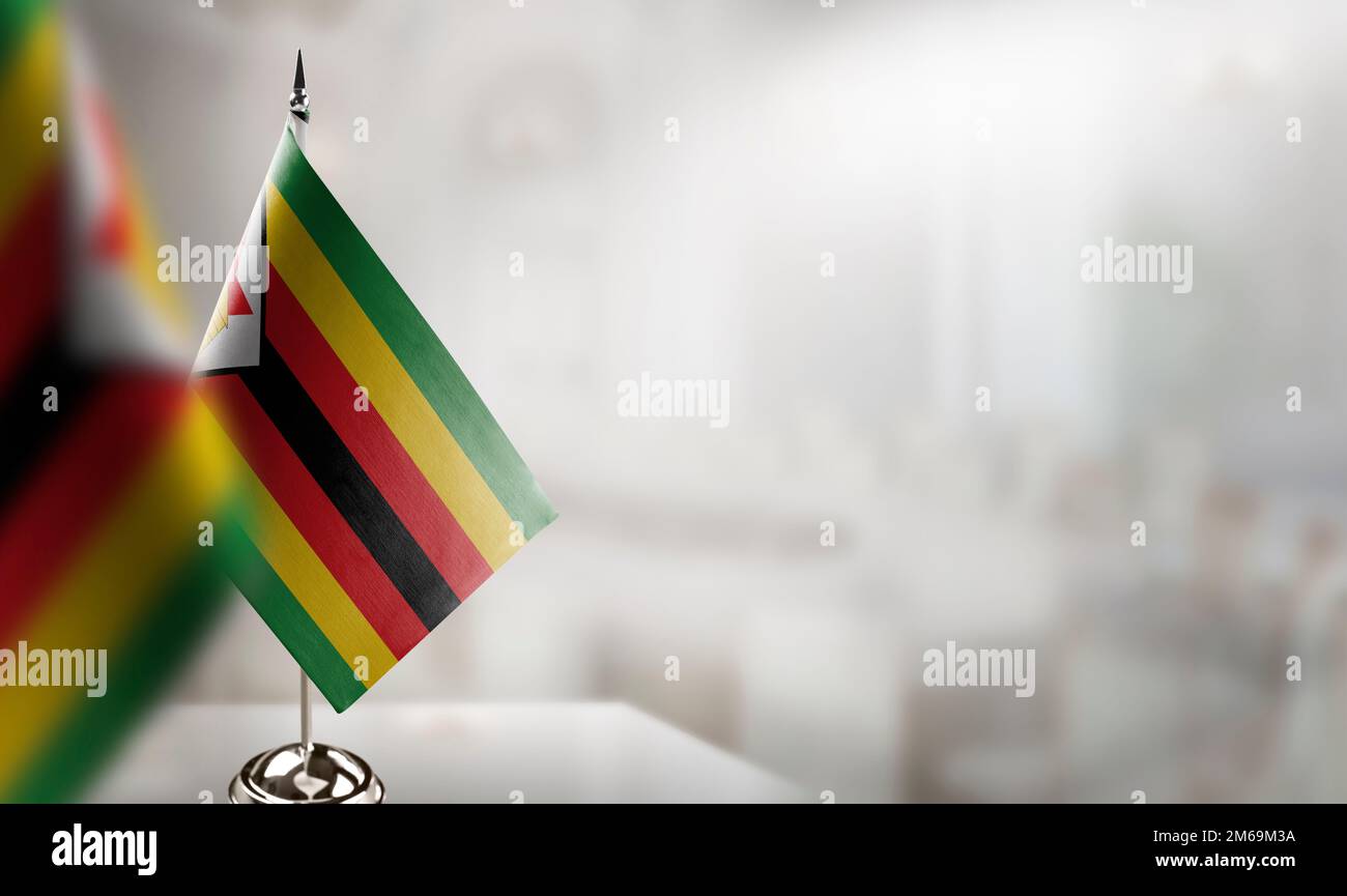 Small flags of the Zimbabwe on an abstract blurry background Stock ...