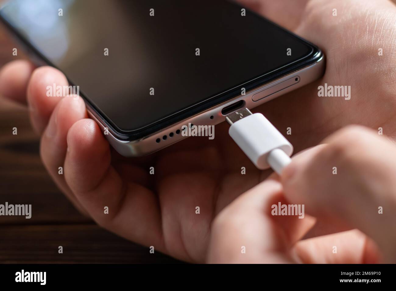 Plugging charger into mobile telephone hi-res stock photography and ...