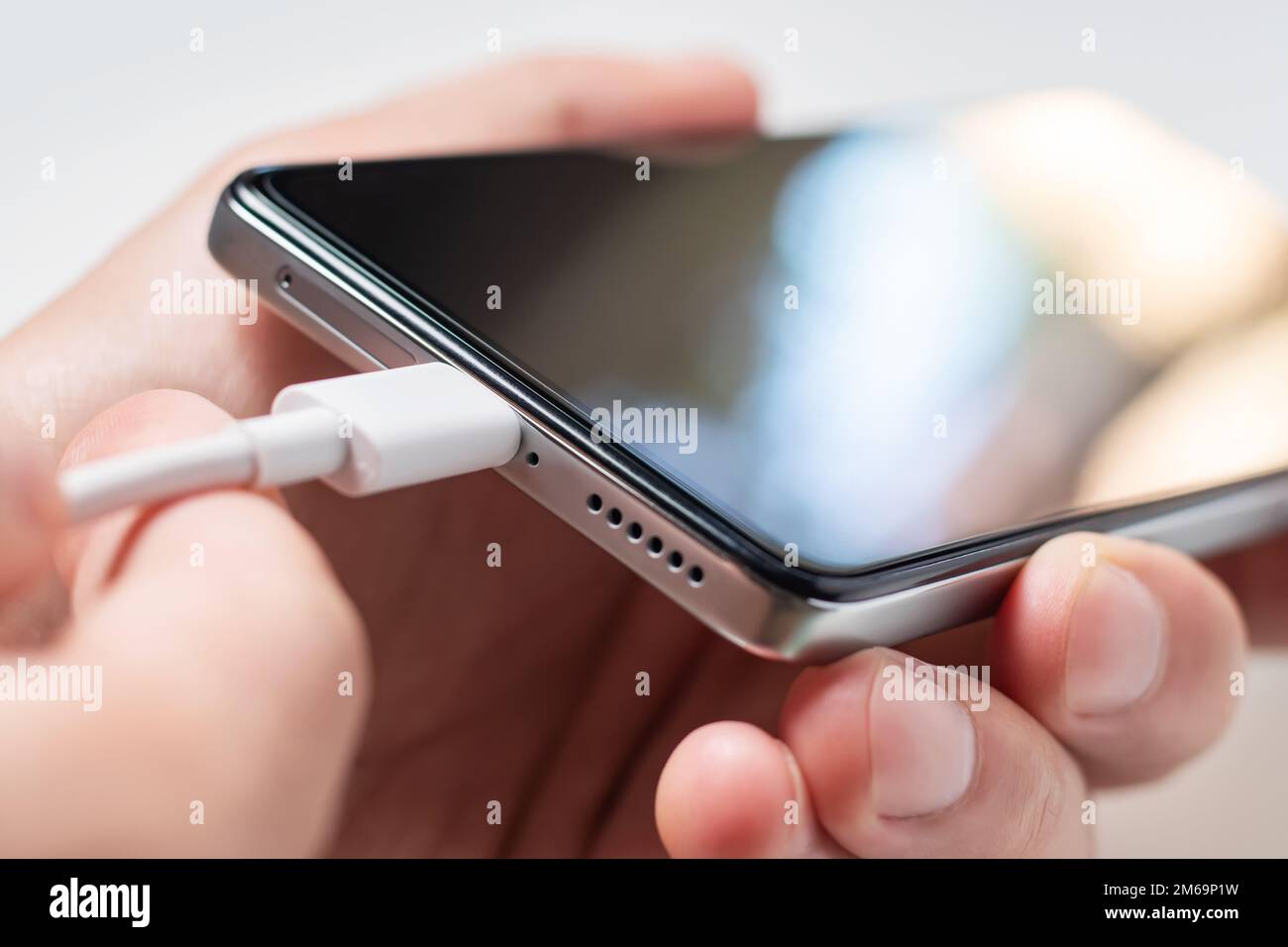 Man hands plugging a charger in a smart phone Stock Photo - Alamy