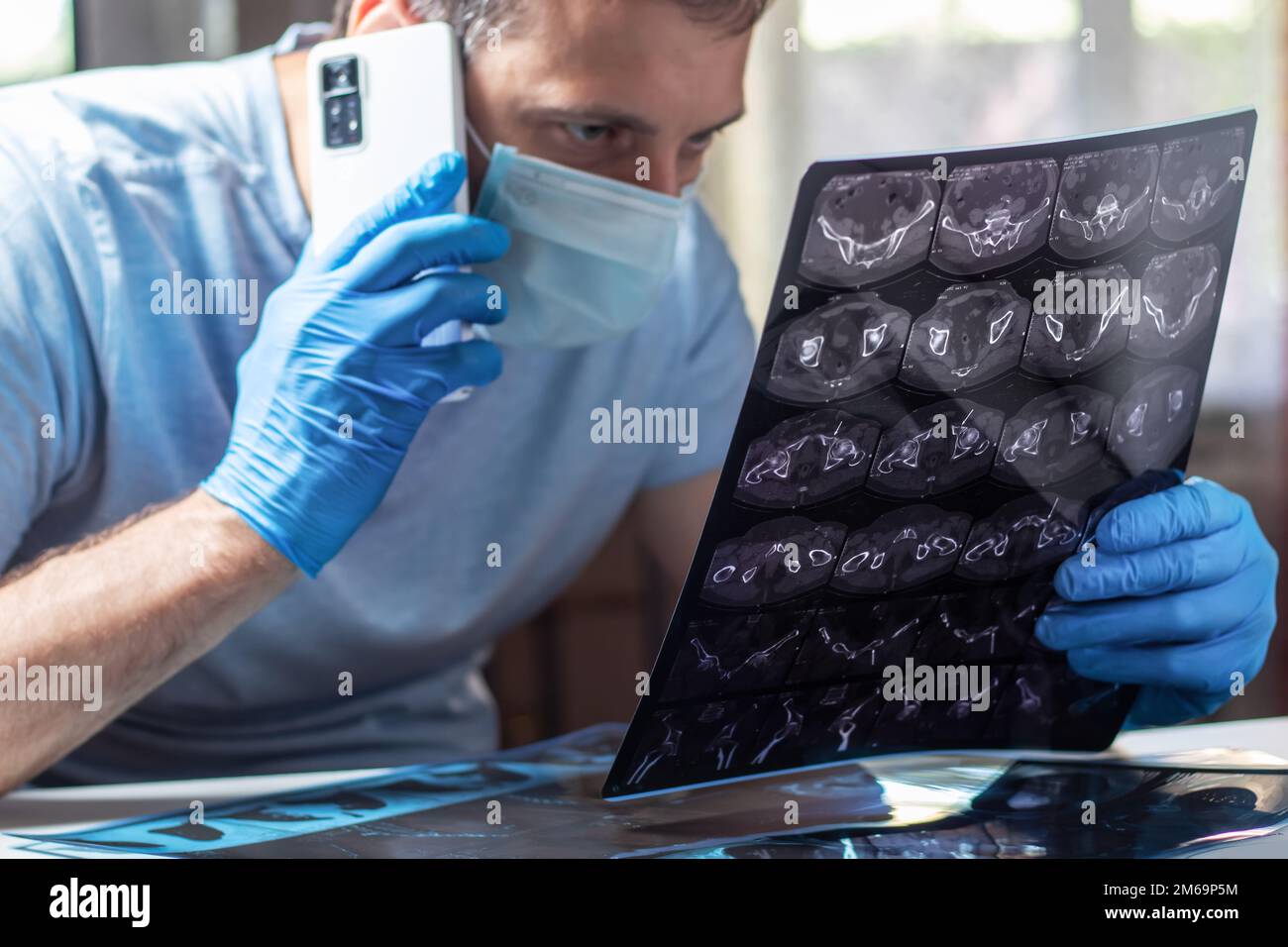 Doctor in mask attentively examines head MRI and calling pacient Stock ...