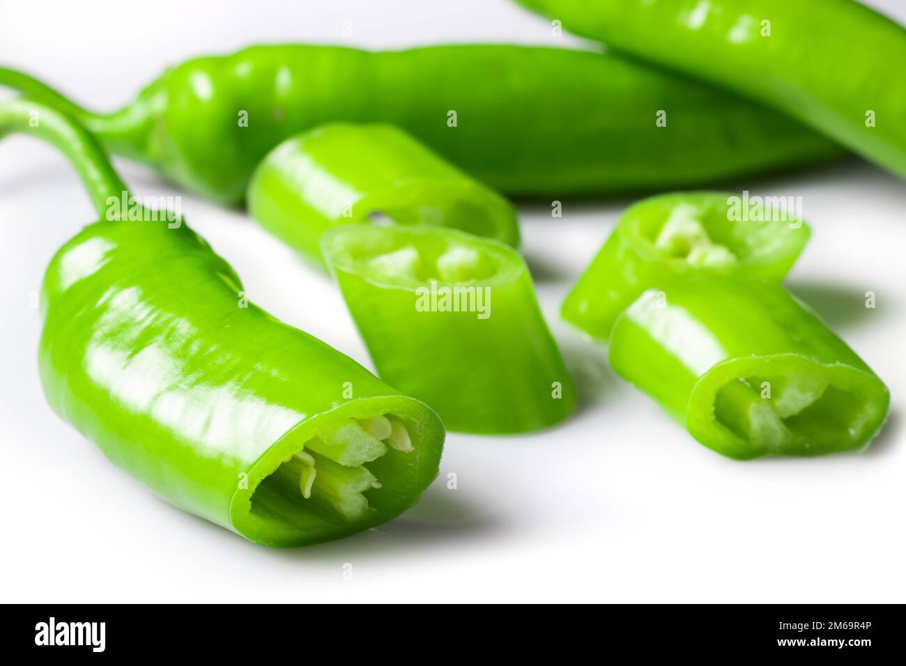 green hot chili peppers with slices isolated on white background Stock Photo - Alamy