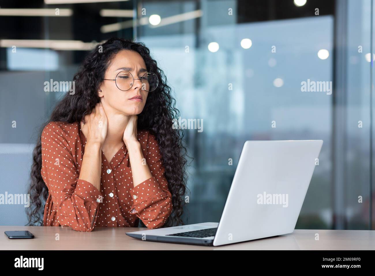 Overtired business woman working inside office with laptop, Hispanic ...