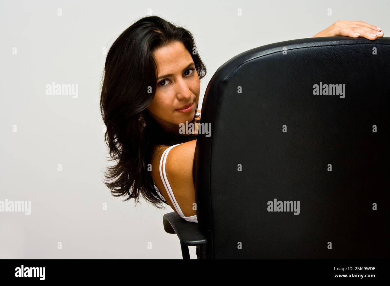 Latina sitting in chair Stock Photo - Alamy