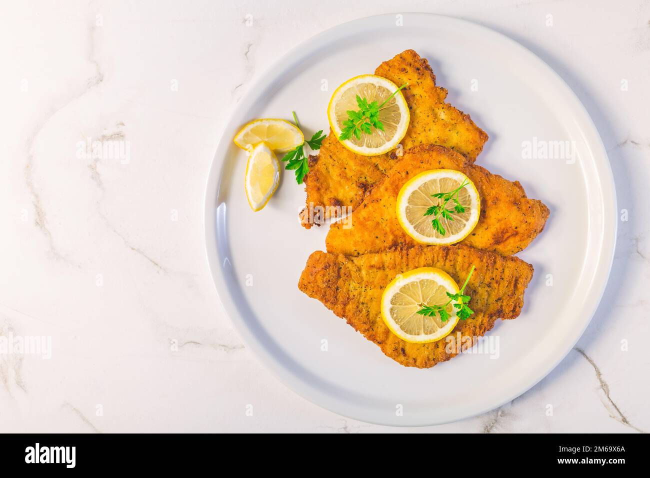 Breaded fish, baked and served with lemon. Common dab, edible flatfisch ...