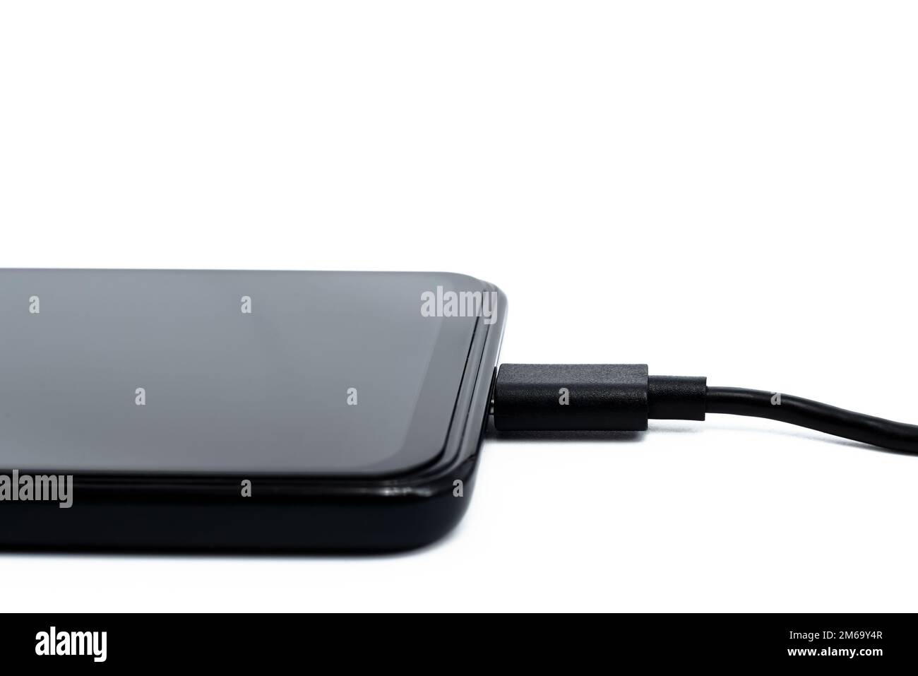 Smartphone charging via usb cable on a white background. Wired charging ...