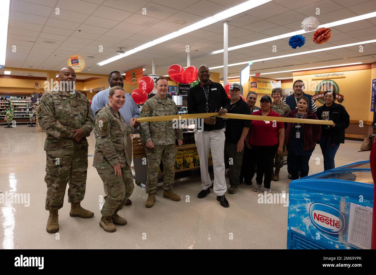 Multiple U.S. Air Force leaders and commissary employees pose during an ...