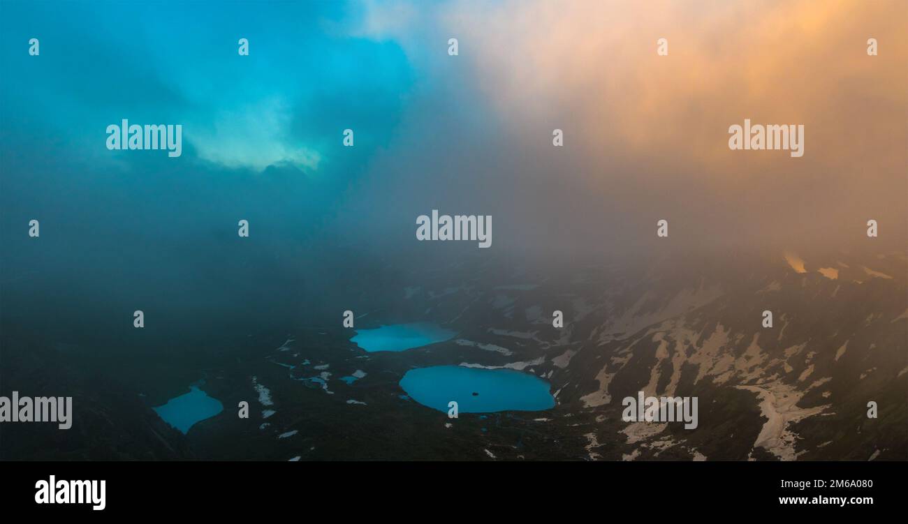 Azgara mountain lakes in last beams of sun. Top view through clouds ...