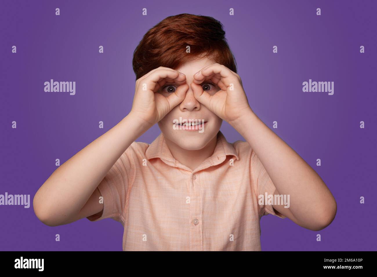 Curious child exploring world looking through fingers shaped like ... Curious child exploring world looking through fingers shaped like ...