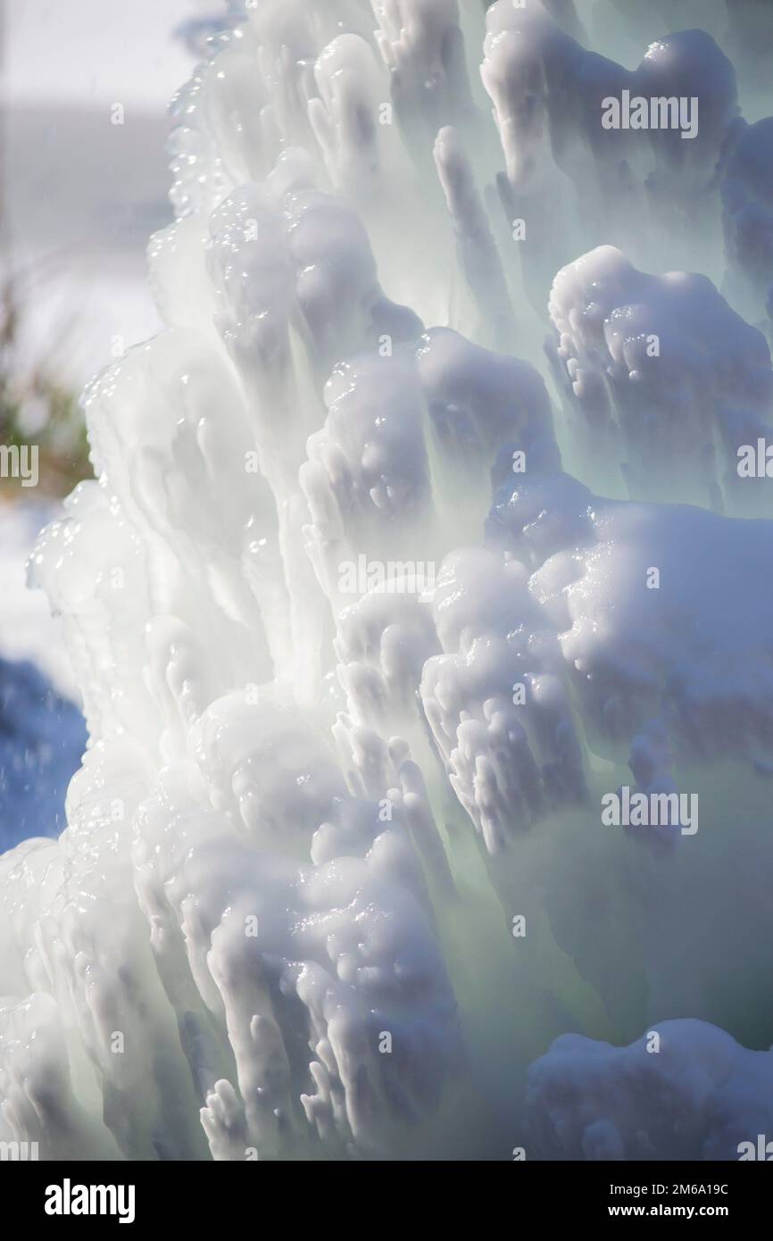 Iced fountain in the park on a winter sunny day. Fountain with frozen ...