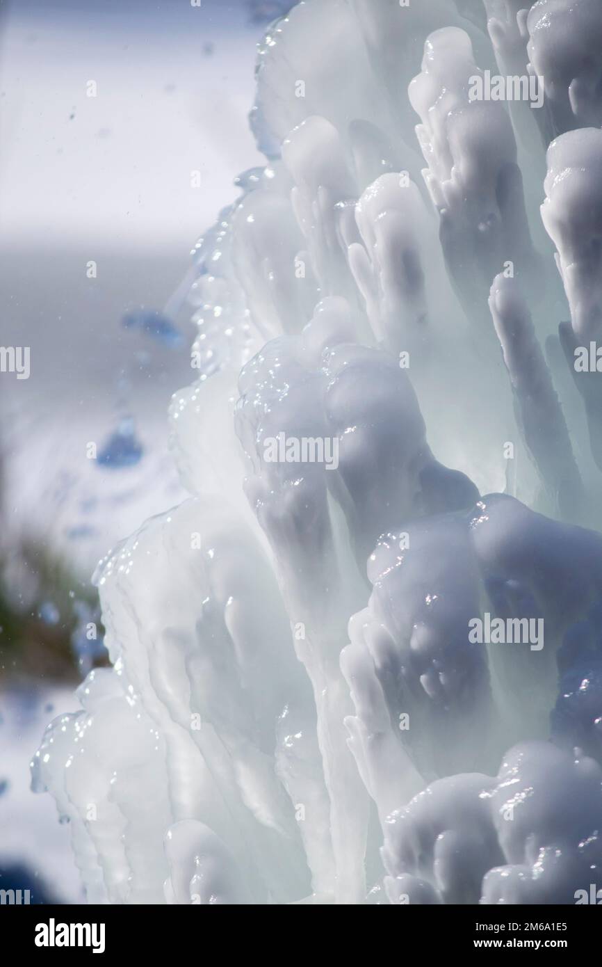 Iced fountain in the park on a winter sunny day. Fountain with frozen ...