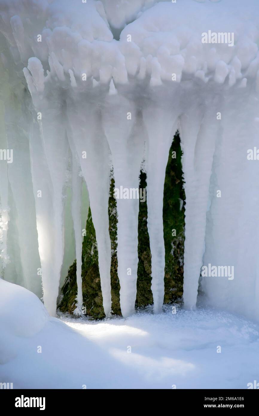 Iced fountain in the park on a winter sunny day. Fountain with frozen ...
