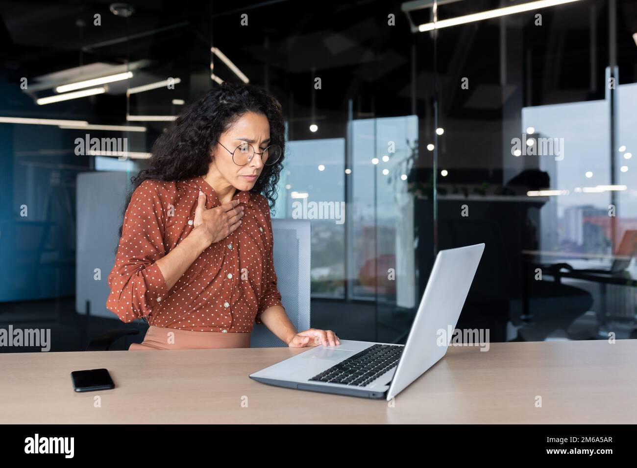 Anxious and scared business woman working inside office, Hispanic woman ...