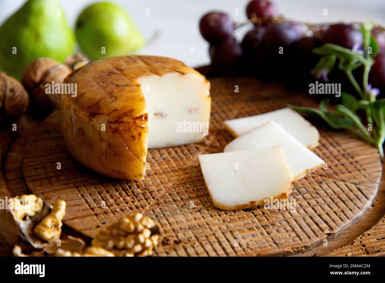 Organic cheese on a wood table with grapes and walnuts Stock Photo - Alamy