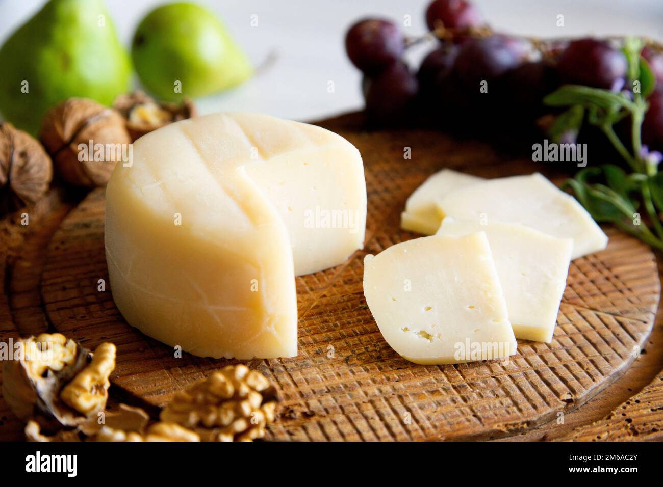 Organic cheese on a wood table with grapes and walnuts Stock Photo - Alamy