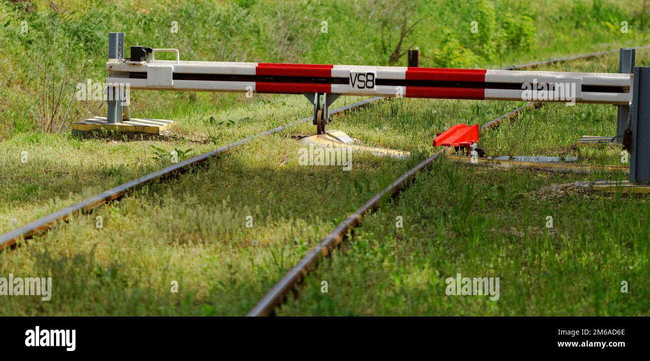 Red white barrier to the railroad tracks with grass Stock Photo - Alamy