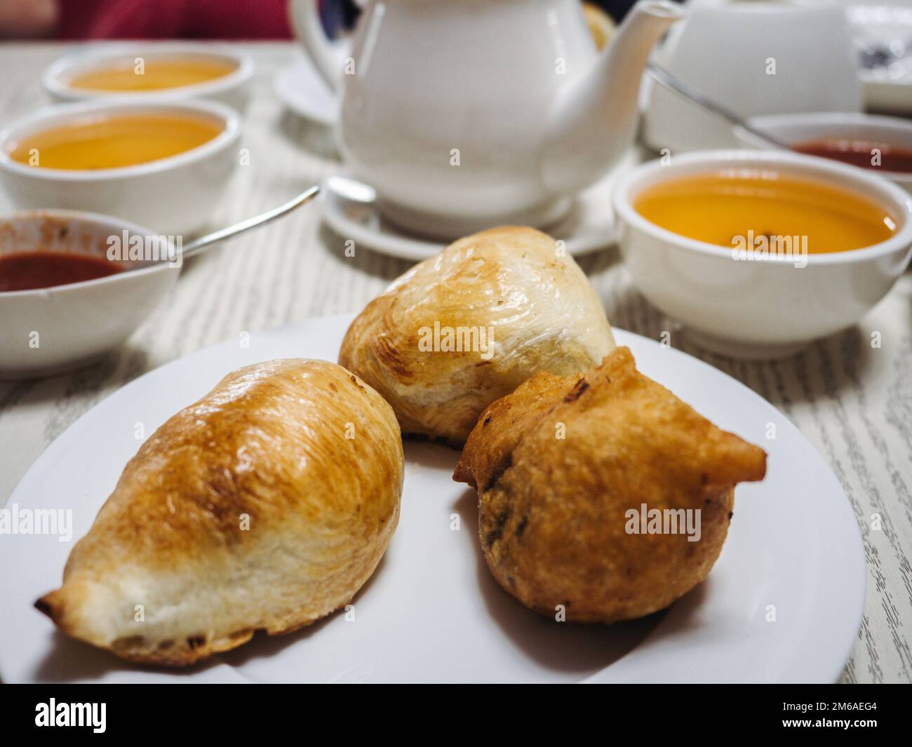 Fresh, hot bun and a cup of fragrant tea. Sunny, clear day. Close-up ...
