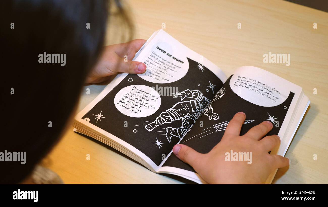 A little girl reading a poetry book. Children and education Stock Photo ...