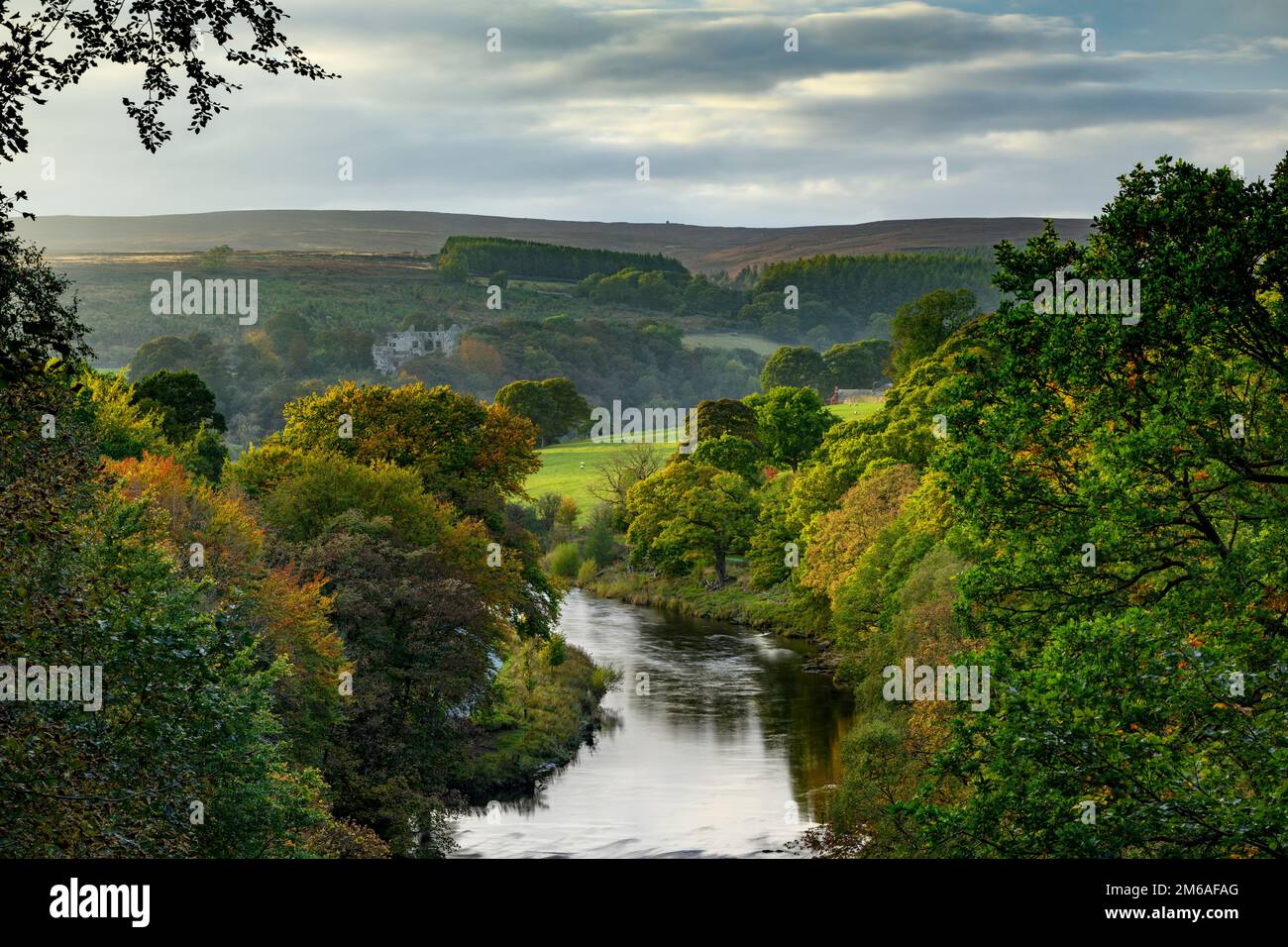 Autumn long-distance view upstream of River Wharfe, old historic Barden ...