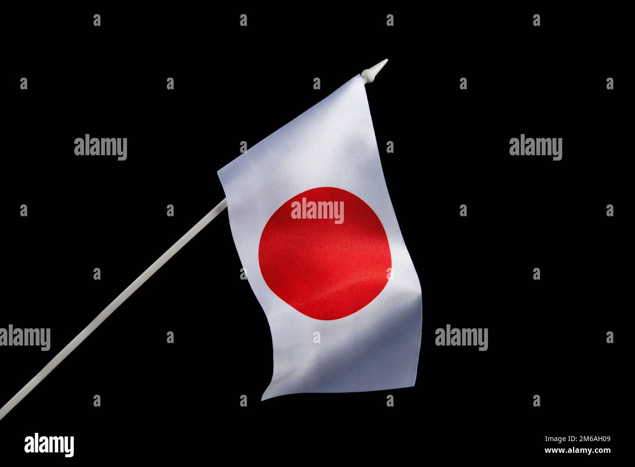 The Japanese flag on a black background developing and flying in the ...
