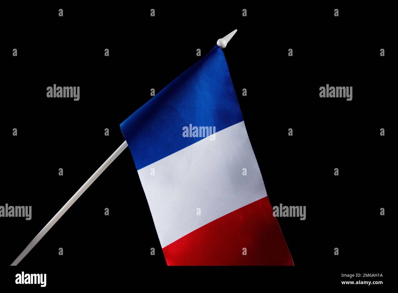 The flag of France on a black background developing flying in the wind ...