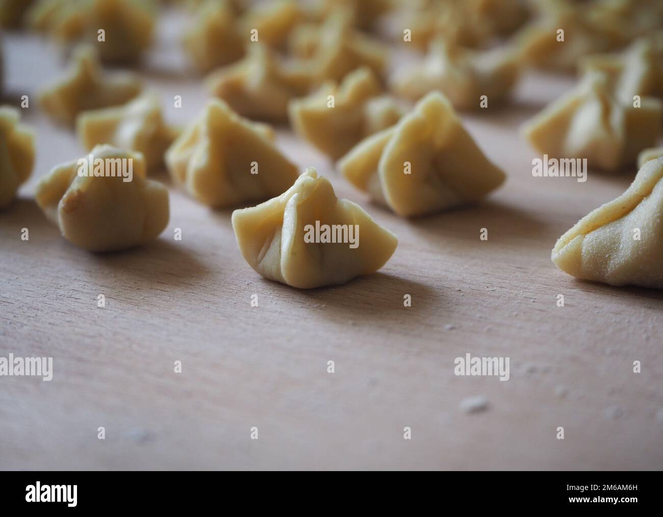 Making the traditional Turkish food Mantı. Raw handmade Turkish ravioli ...