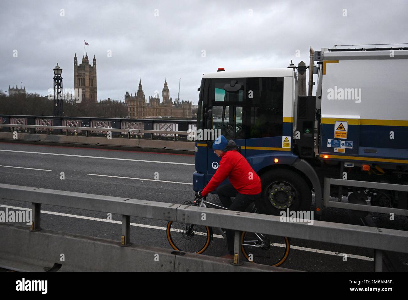 A cyclist rides near the crash barrier whilst being overtaken by a ...