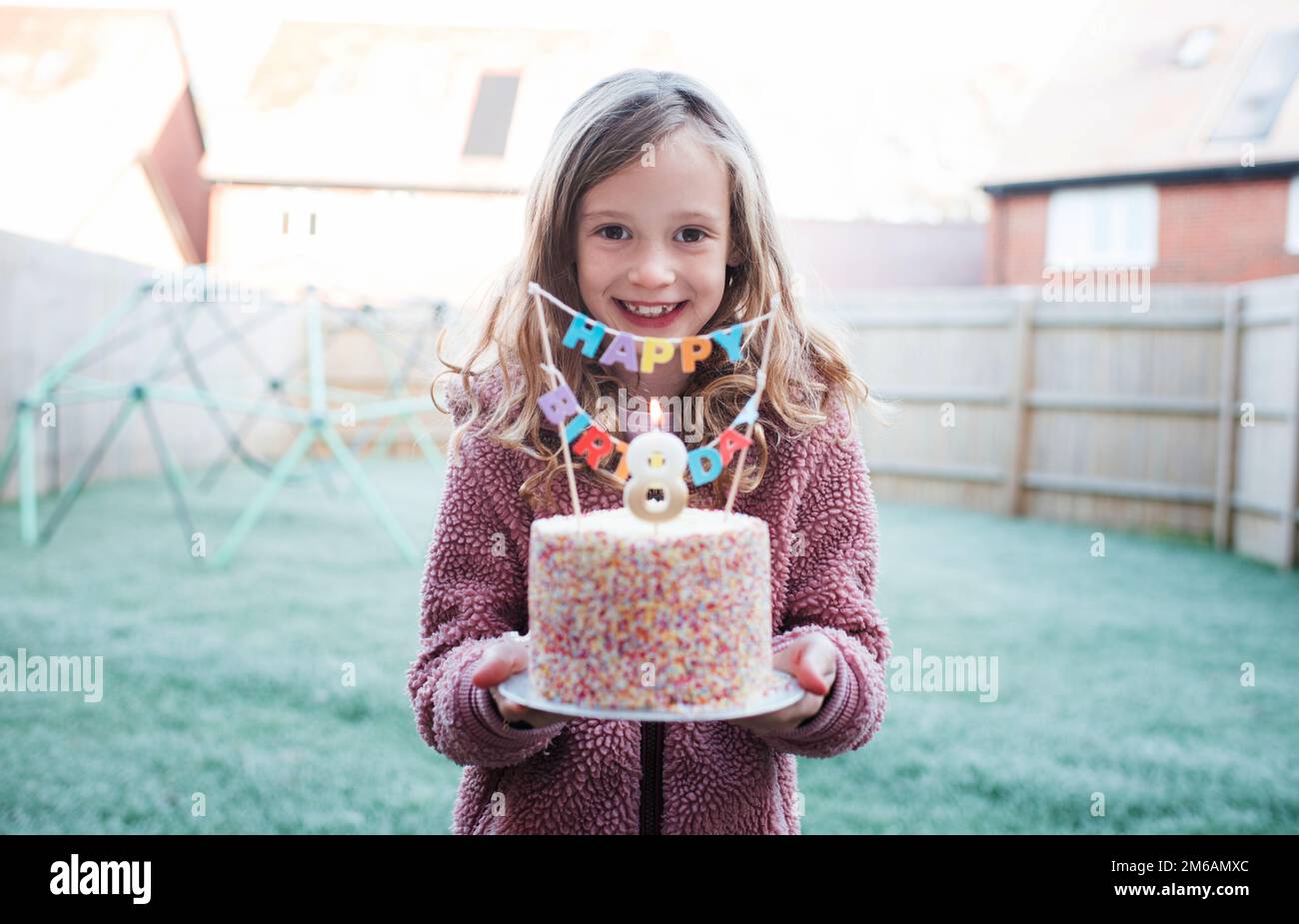 girl smiling celebrating her 8th birthday with a cake Stock Photo - Alamy
