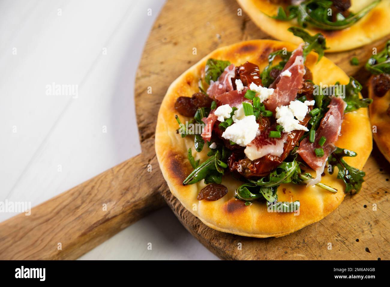 Mini pizza with Spanish Iberico ham, arugula and cheese Stock Photo - Alamy