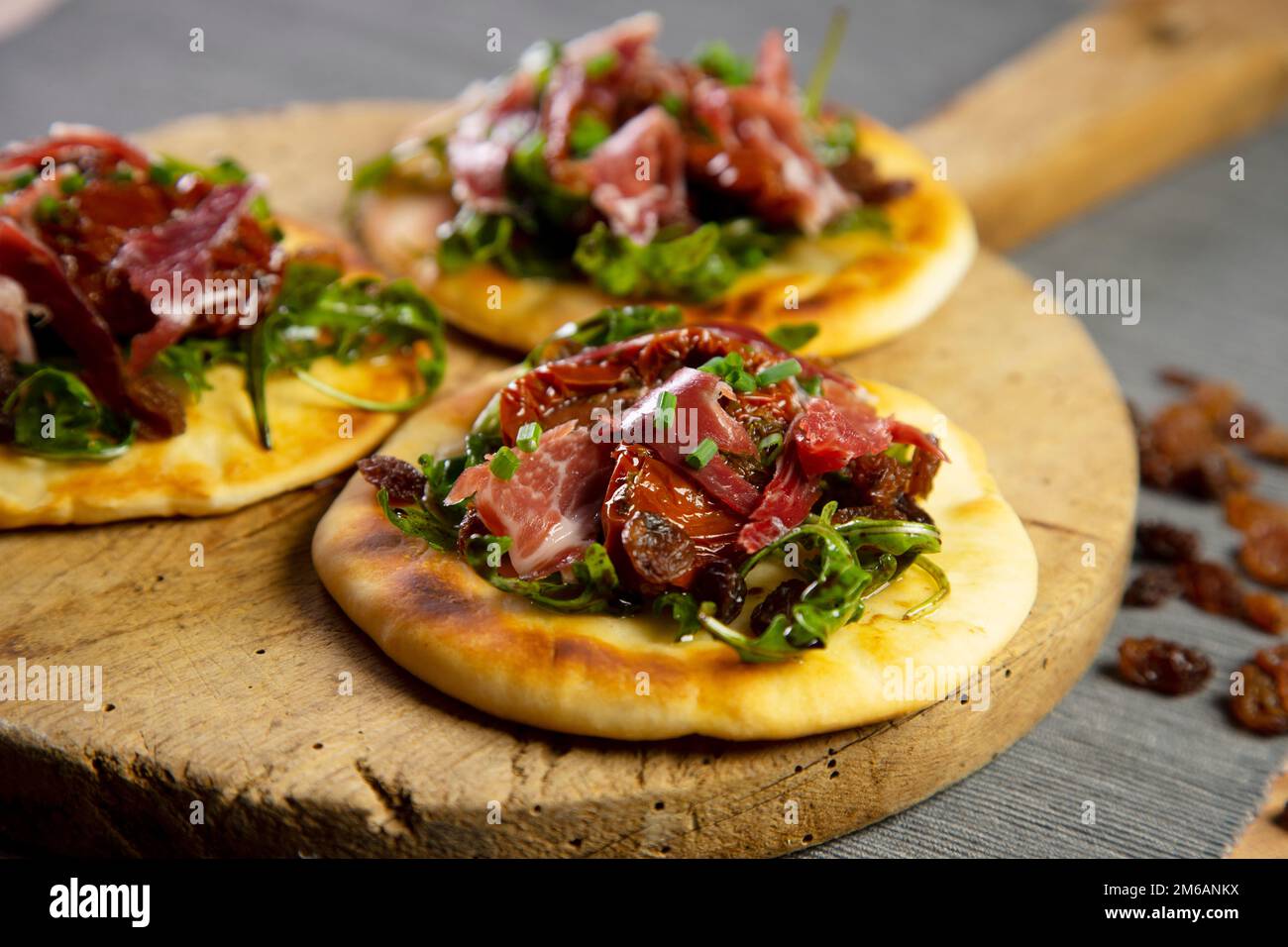 Mini pizza with Spanish Iberico ham, arugula and cheese Stock Photo - Alamy