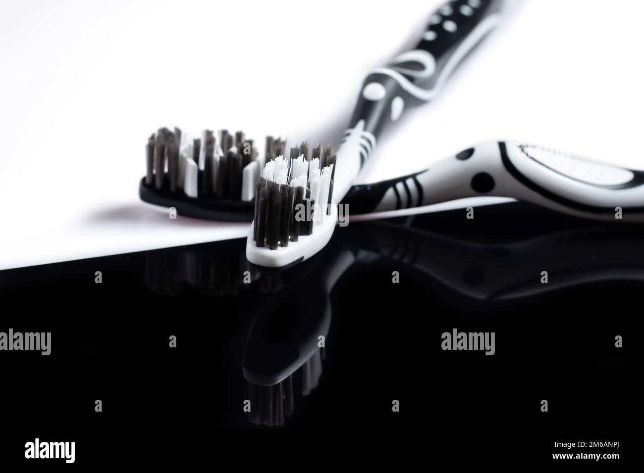 Two toothbrushes black and white color for dental care lies on a white ...