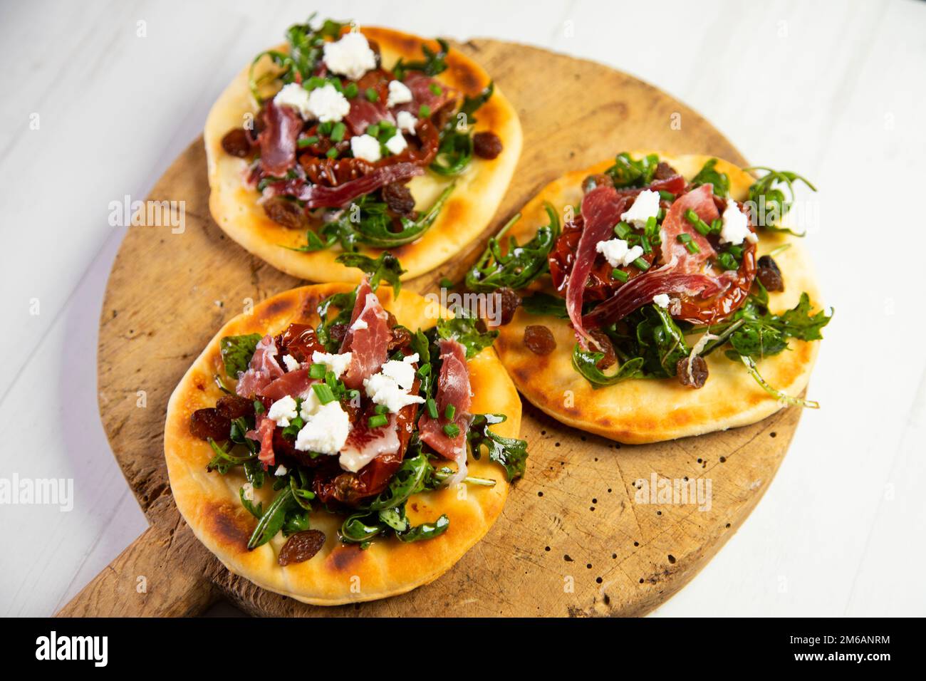 Mini pizza with Spanish Iberico ham, arugula and cheese Stock Photo - Alamy