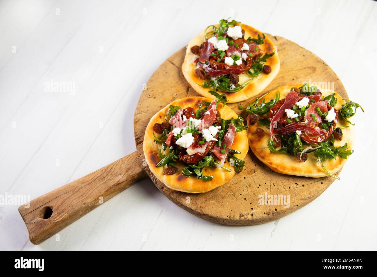 Mini pizza with Spanish Iberico ham, arugula and cheese Stock Photo - Alamy