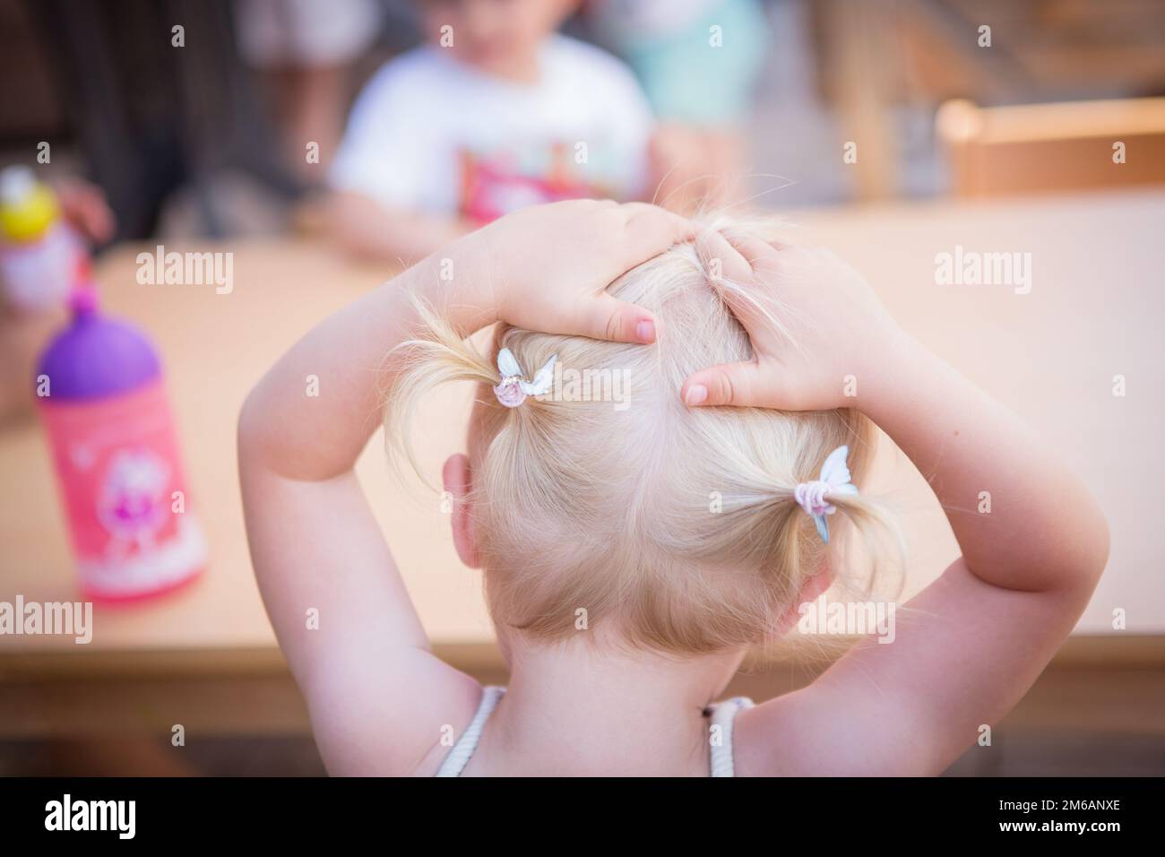little girl sitting at the table Stock Photo - Alamy