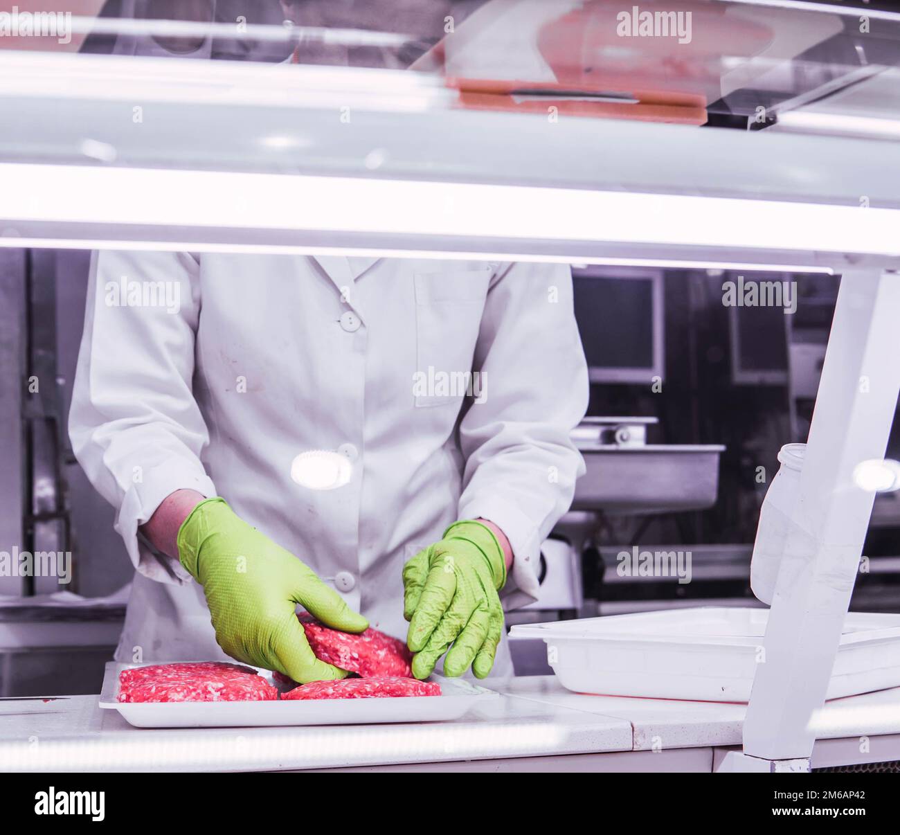 butcher placing the burgers on a tray Stock Photo - Alamy