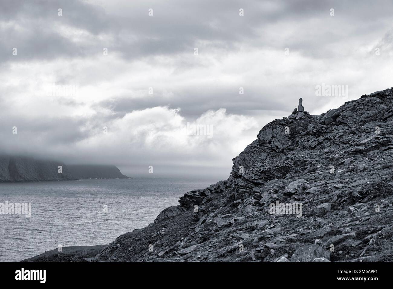Rocky coast near Skarsvag with view to the North Cape, monochrome ...