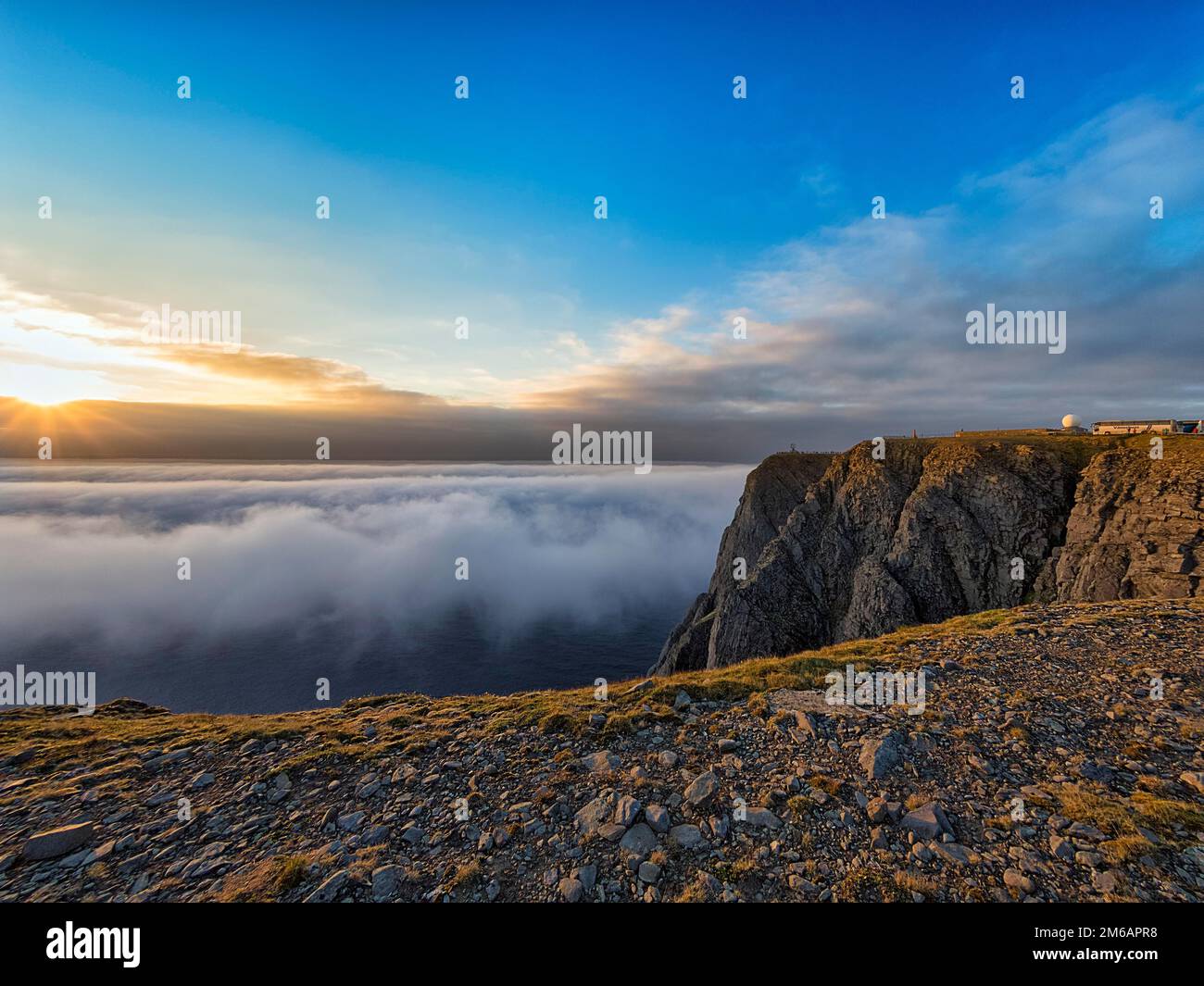 Rocky shale coast, sea of clouds with midnight sun, visitor platform on ...