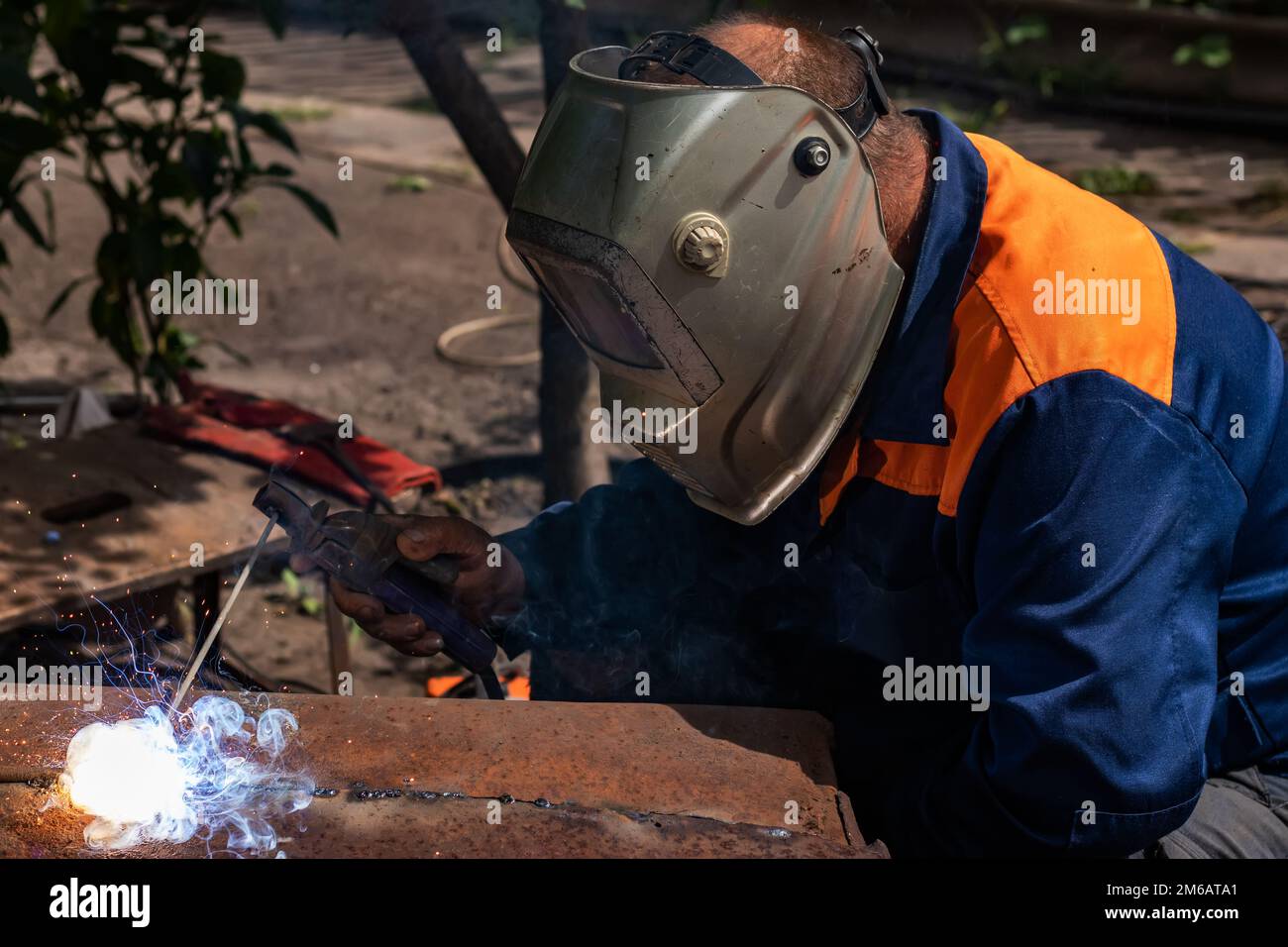 Worker wearing industrial uniforms and Welded Mask industrial safety ...