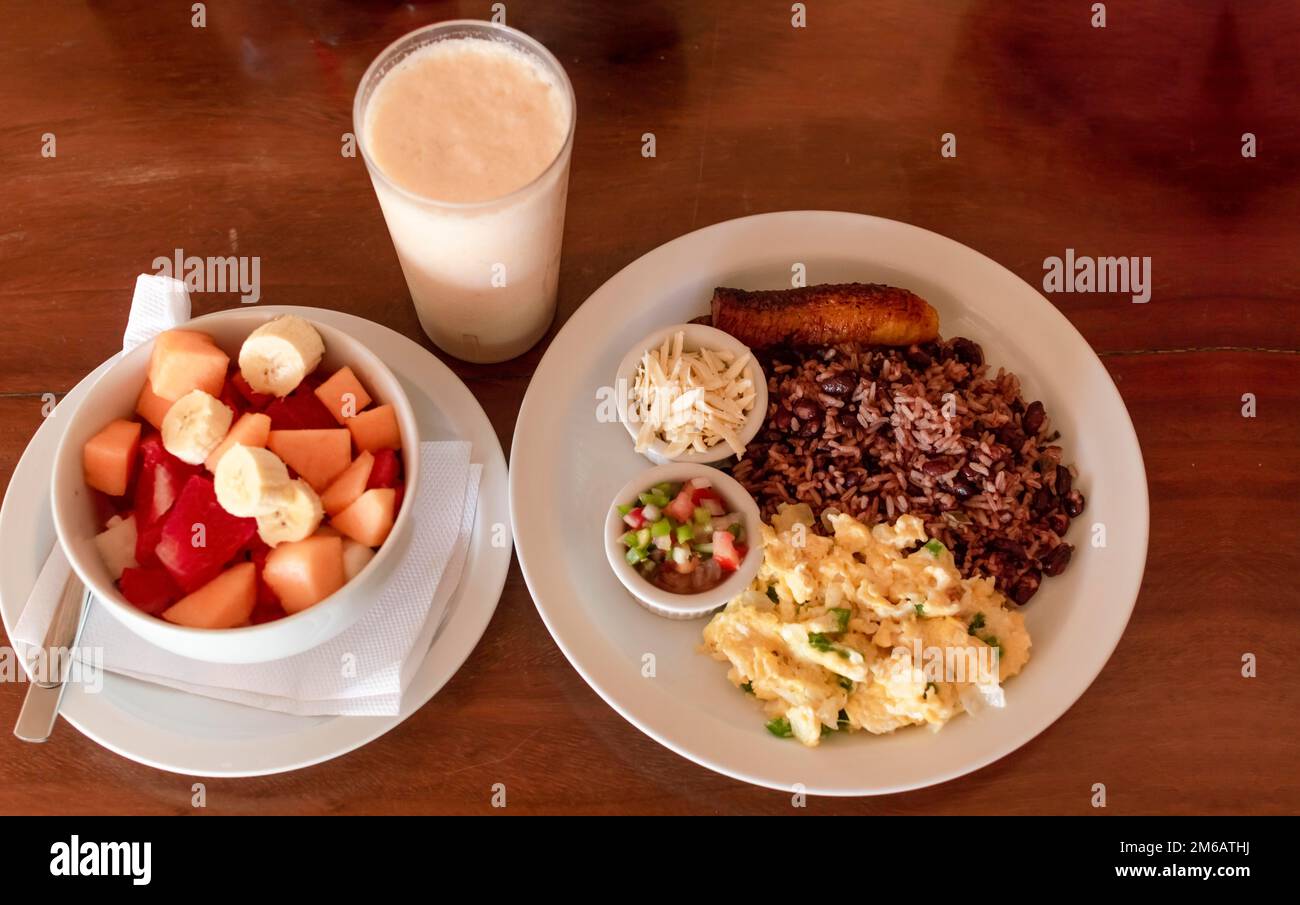 Gallo pinto breakfast served on the table with a fruit salad ...
