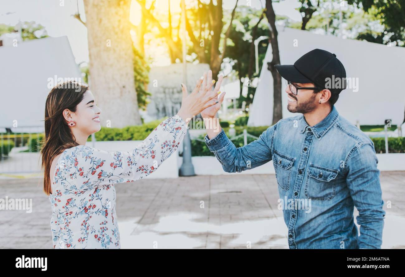 A girl and a guy shaking hands on the street. Two young smiling ...